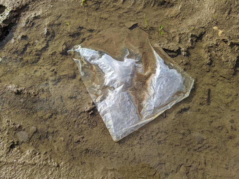 Plastic Bag in a Mud Puddle during the Day. Stock Photo - Image of land ...