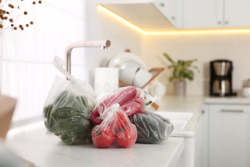 Plastic Bags with Different Fresh Products on White Countertop in ...
