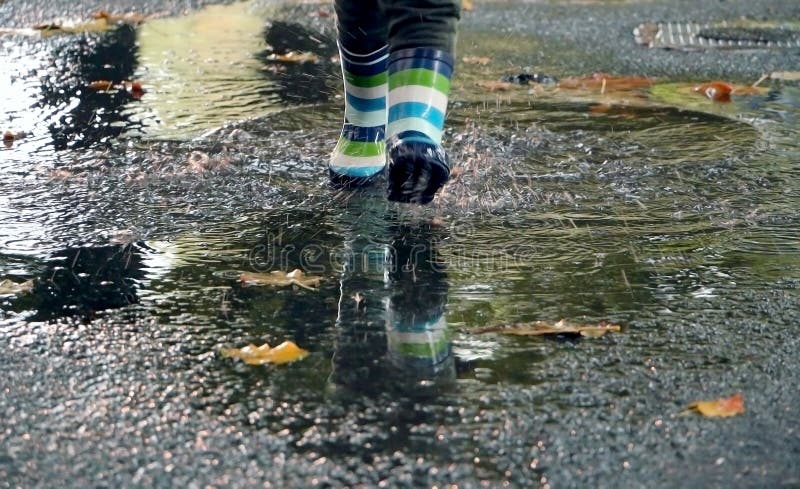 Plastic Boots Running through the Puddle in Autumn Stock Photo - Image ...