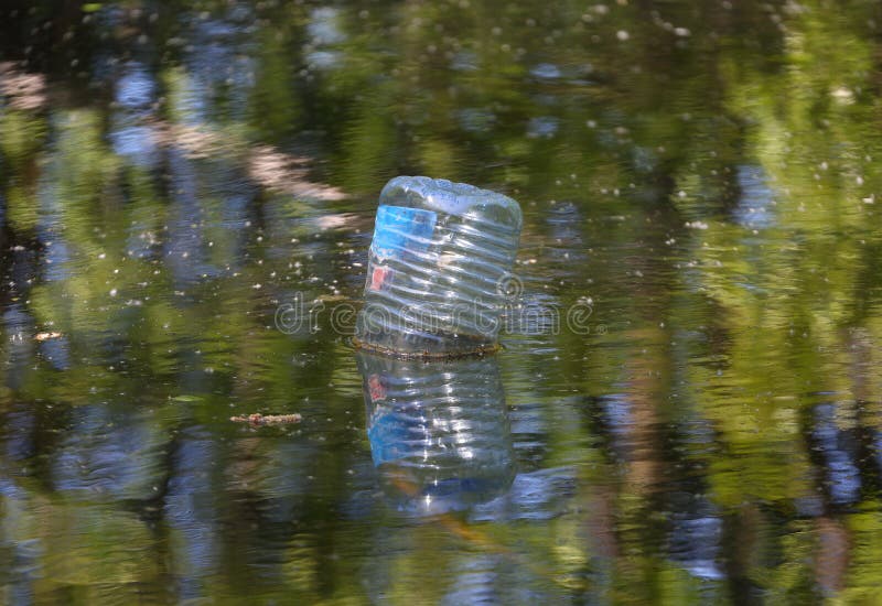 A Plastic Bottle Floats Upside Down in the Murky Green Water Stock ...