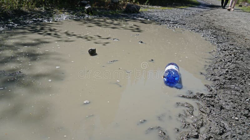 A Plastic Bottle Is Lying In A Muddy Puddle. Stock Photo - Image of ...