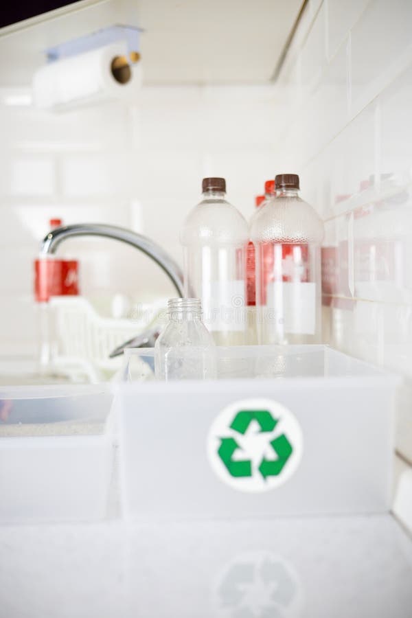 Plastic Bottles Stand in the Kitchen Against the Backdrop of Trash Cans ...