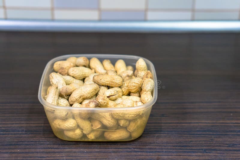 Plastic Box Filled with Peanuts on a Wooden Surface Stock Image - Image ...