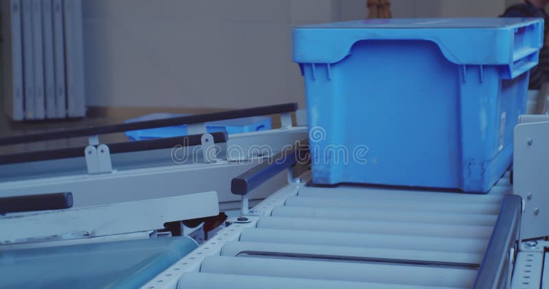 The Plastic Box Moves on a Roller Conveyor Inside the Warehouse. Modern ...