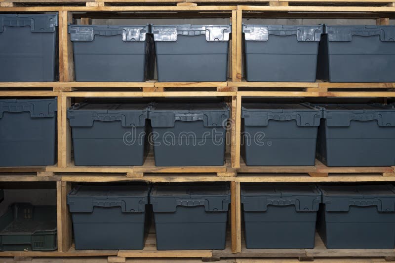 Plastic Boxes are Arranged in a Row on Wooden Racks Made of Pallets ...