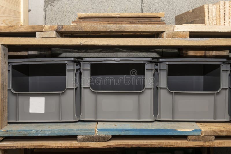Plastic Boxes are Arranged in a Row on Wooden Racks Made of Pallets ...