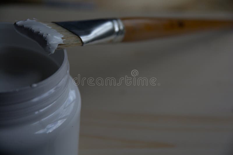Plastic Can with White Acrylic Primer and a Bristle Brush on a Wooden ...