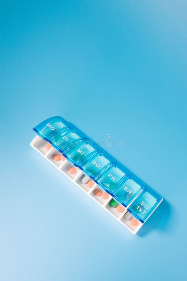 Plastic Container with Various Pills on a Blue Background. Planning the ...