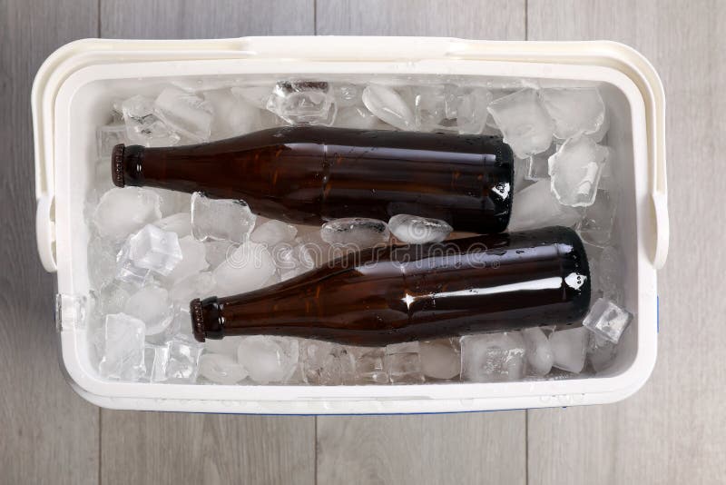 Plastic Cool Box with Ice Cubes and Beer on Wooden Floor, Top View ...
