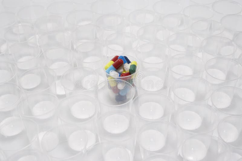 Plastic Cup Containing Pills Surrounded by Empty Glasses Stock Photo ...