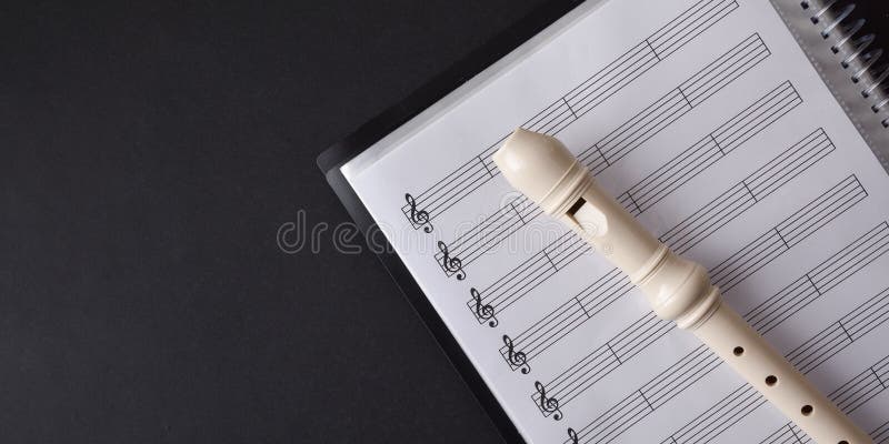 Plastic Recorder on Sheet Music Folder on a Black Table Stock Photo ...