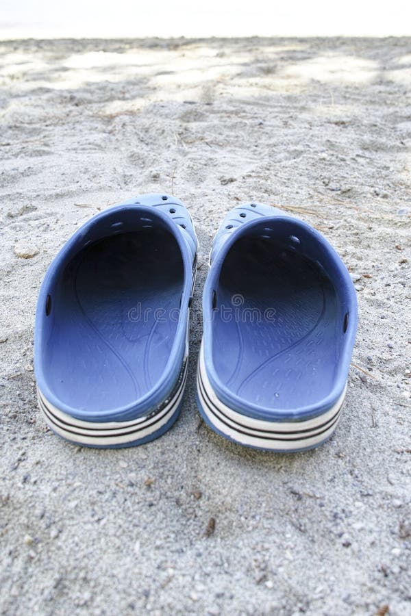 Plastic shoes on the beach stock photo. Image of accident - 95966516