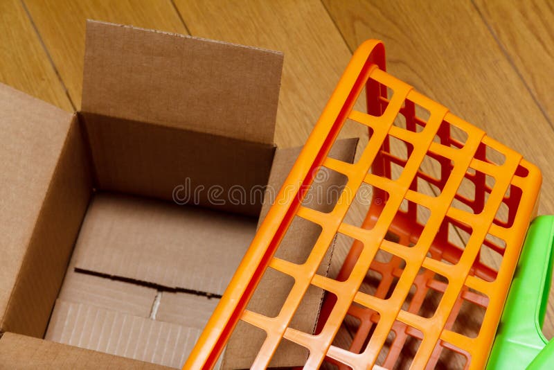 Plastic Shopping Basket on the Floor and an Open Cardboard Box Stock ...