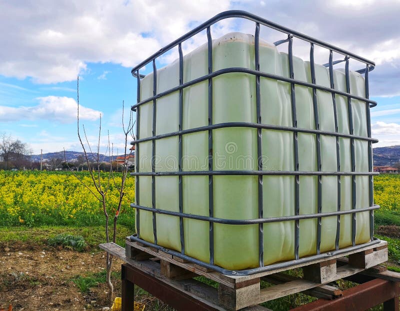 Plastic Water Tank in a Farm Field Under a Blue Cloudy Sky and Sunlight ...