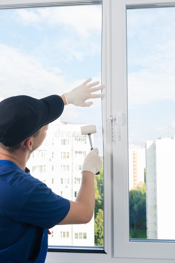 Plastic Window Installation Wizard Fastens Glass with a Rubber Mallet ...