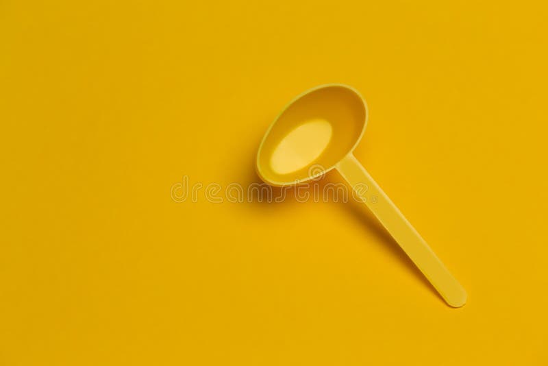Plastic Yellow Spoon Over Yellow Background Stock Photo - Image of ...