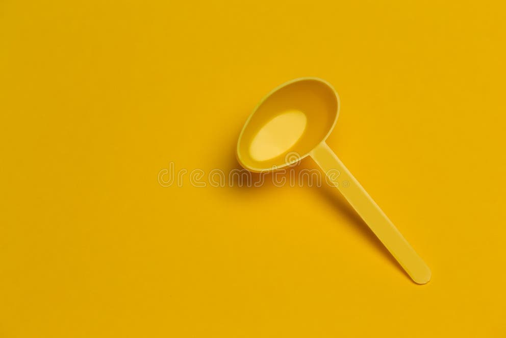 Plastic Yellow Spoon Over Yellow Background Stock Photo - Image of ...