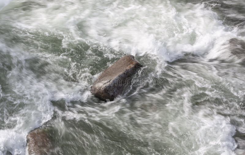A Rock with Water Flowing Around it Stock Photo - Image of brutal ...