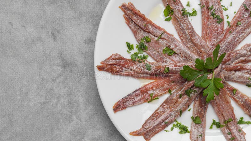 Plate with Anchovy Fillets and Parsley on Grey Table, Top View. Space ...