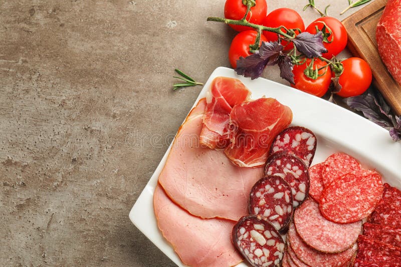 Plate with Assortment of Delicious Deli Meats on Table Stock Photo ...