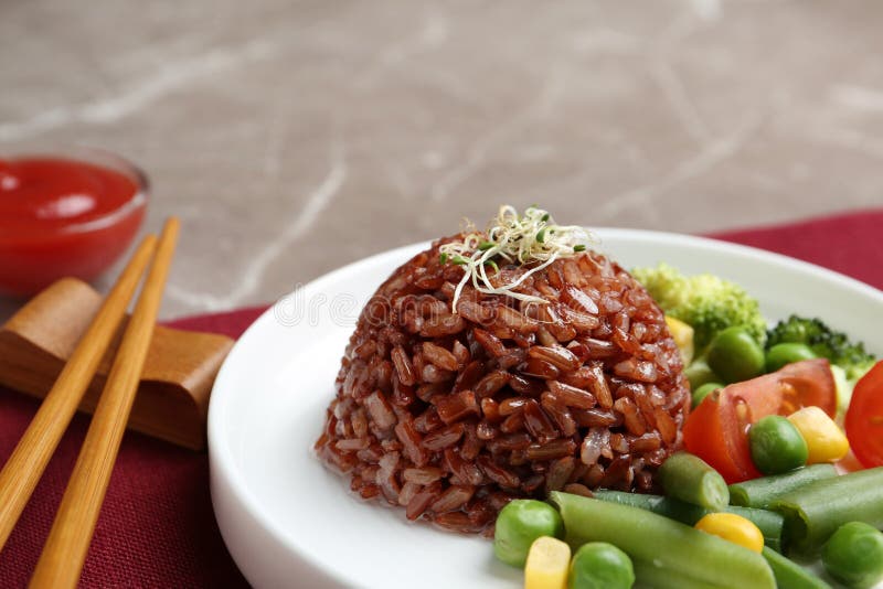 Plate of Boiled Brown Rice with Vegetables on Table, Closeup. Space for ...
