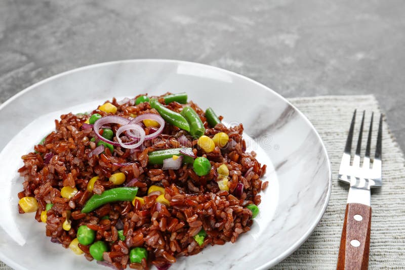 Plate of Boiled Brown Rice with Vegetables on Table, Closeup. Stock ...