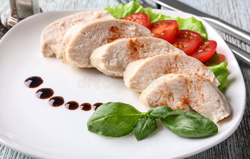 Plate with Boiled Chicken Fillet and Garnish on Table, Closeup Stock ...