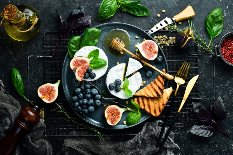 A Plate with Brie Cheese, with Honey and Figs. on a Concrete Background ...