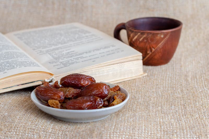 A Plate of Dates and Raisins Near a Cup of Coffee and an Open Book ...