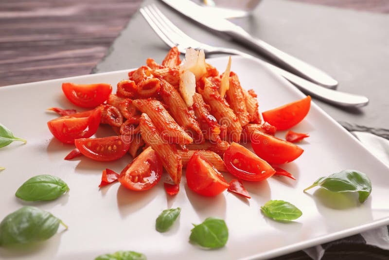 Plate with Delicious Penne Pasta and Garnish on Table, Closeup Stock ...