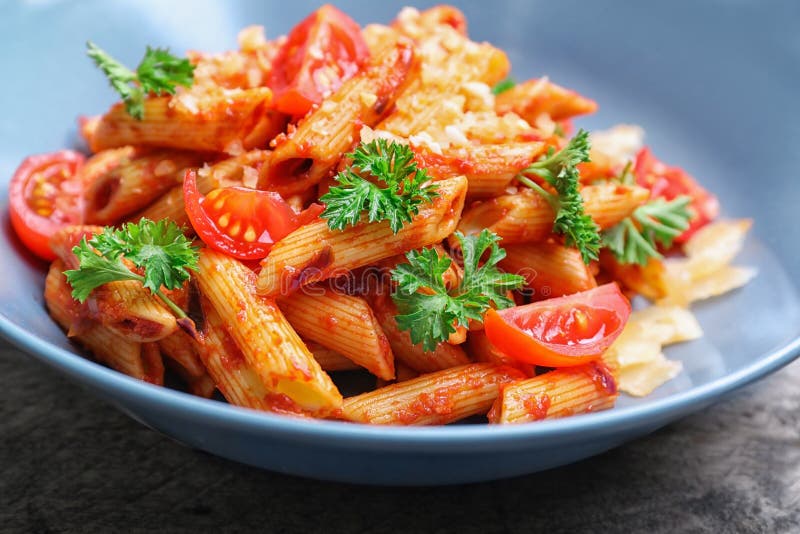 Plate with Delicious Penne Pasta and Garnish on Table, Closeup Stock ...