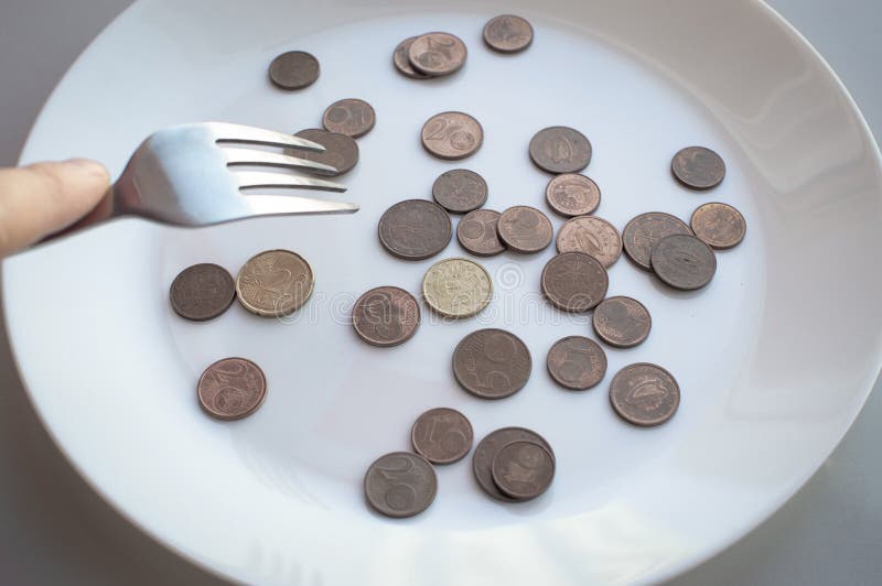 A Plate of Euro Coins with a Fork. Money and Wasting Money Concept ...