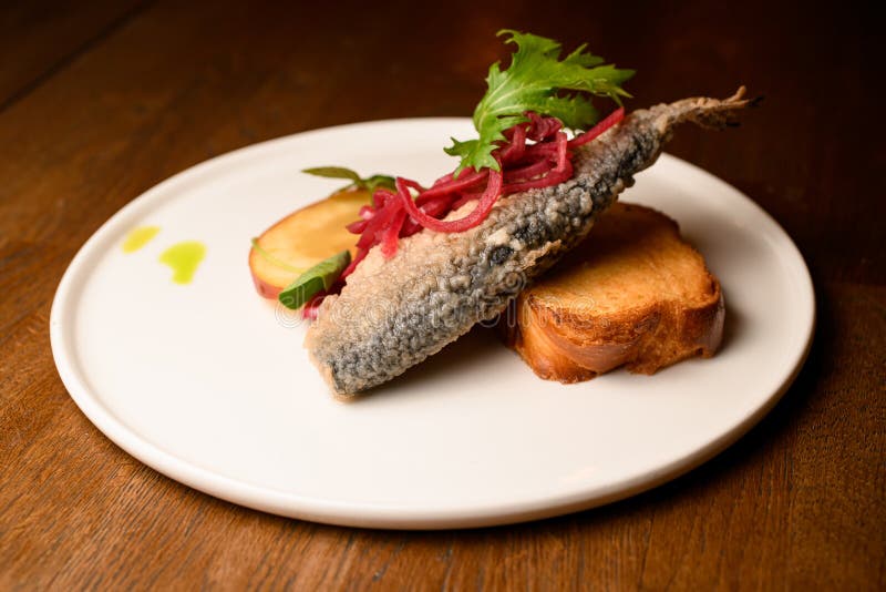Plate of Fried Fish Garnished with Onion and Lemon and Toast on Table ...