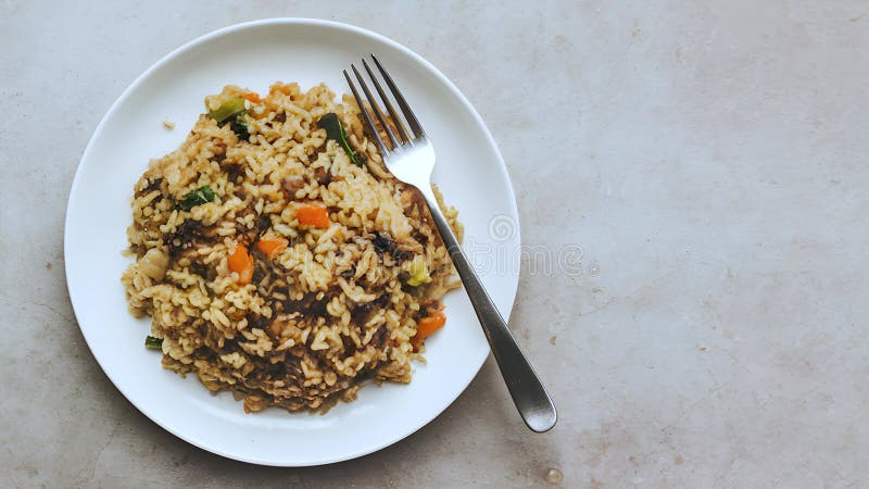 Plate of Fried Rice with Vegetables and Meat, Fork Placed Centrally ...