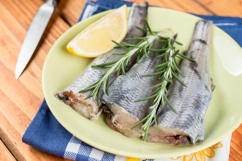 Plate Full with Raw Hake Fish and Lemon and Rosemary Branch Stock Image ...