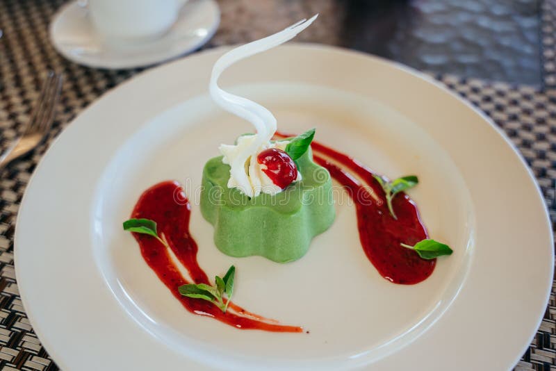 Plate of Green Panna Cotta Desert Decorated with Jam and Green Leaves ...