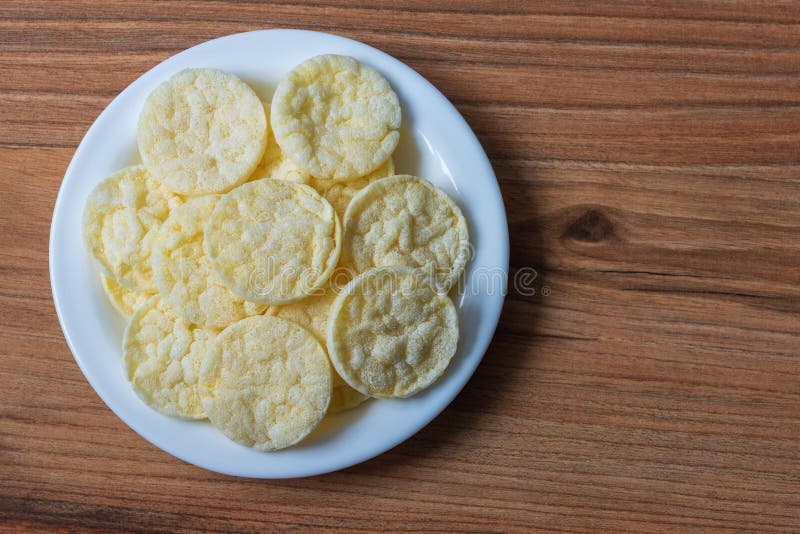 A Plate of Many Round Rice Chips with Cheese Flavor on a Pine Table ...