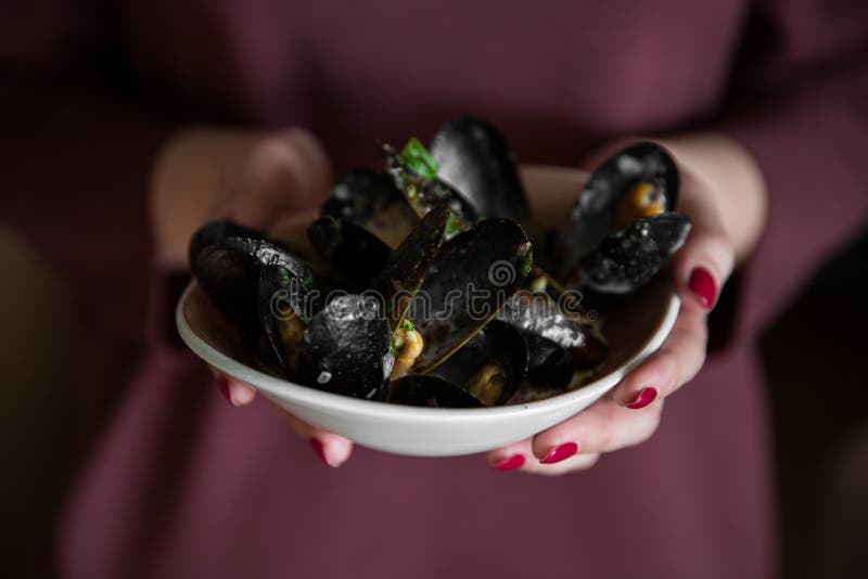 A Plate of Mussels in the Hands of a Female Stock Image - Image of food ...