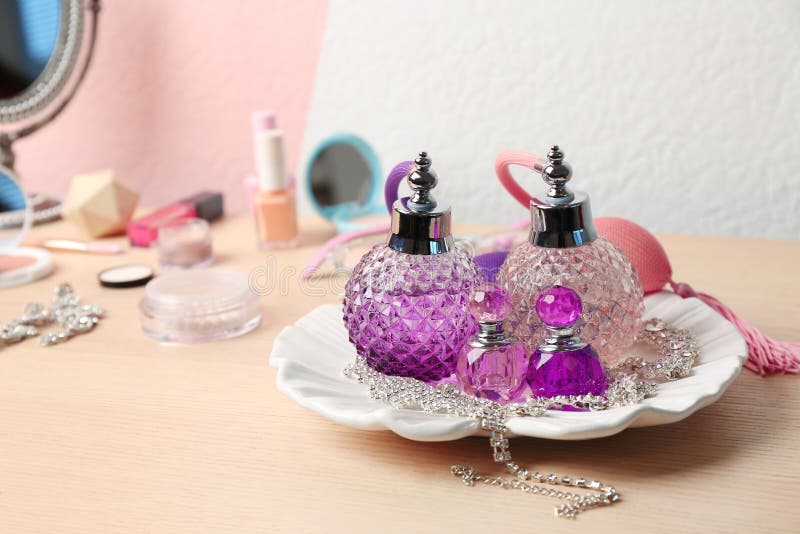 Plate with Perfume Bottles and Jewellery on Dressing Table Stock Photo ...