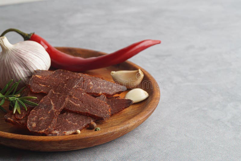 Plate with Pieces of Delicious Beef Jerky and Spices on Light Grey ...