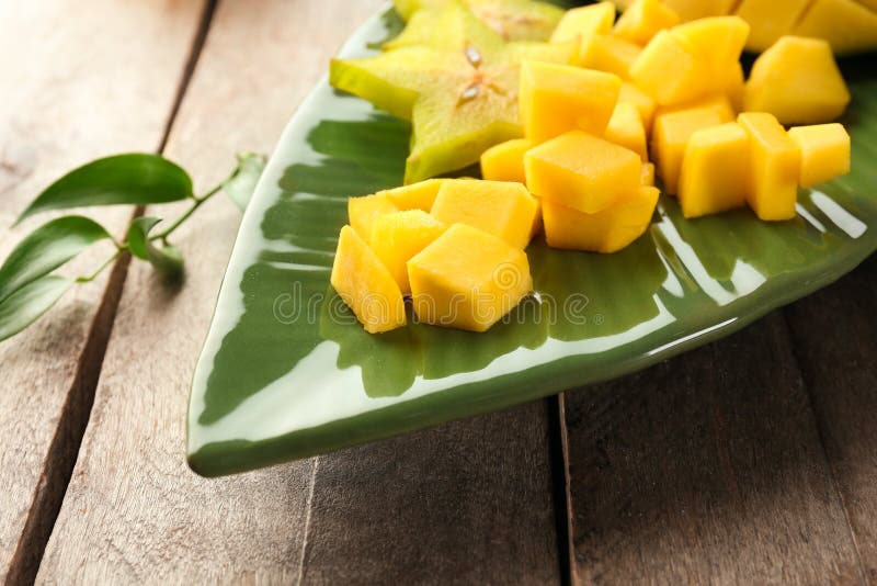 Plate with Pieces of Fresh Mango and Starfruit on Wooden Table, Closeup ...