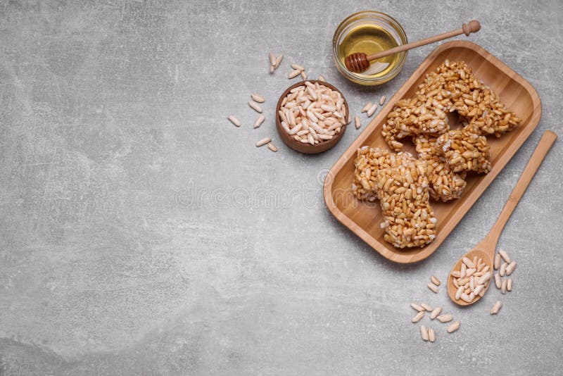 Plate with Puffed Rice Pieces Kozinaki on Grey Table, Flat Lay. Space ...