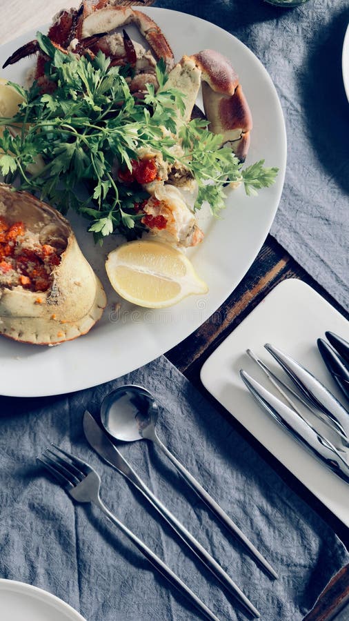 A Plate of Ready-to-eat Crab with Lemon and Herbs is on a Served Table ...