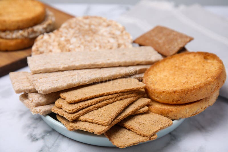 Plate of Rye Crispbreads, Rice Cakes and Rusks on White Marble Table ...