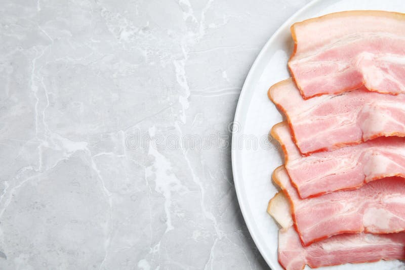 Plate of Sliced Raw Bacon on Light Grey Marble Table. Space for Text ...