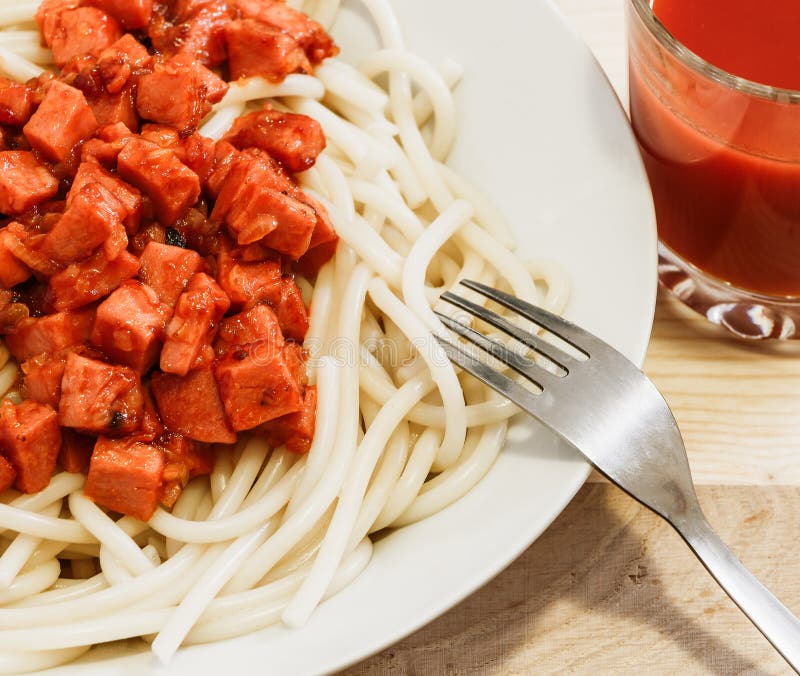 A Plate of Spaghetti with Sausage and a Glass of Tomato Juice on the ...