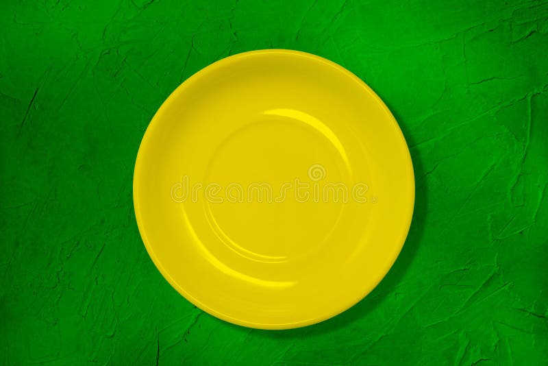 The Plate on the Table. Yellow Empty Plate on a Green Table with ...