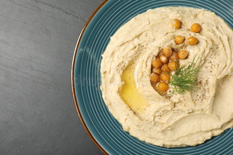 Plate of Tasty Hummus with Garnish on Black Table, Top View Stock Photo ...