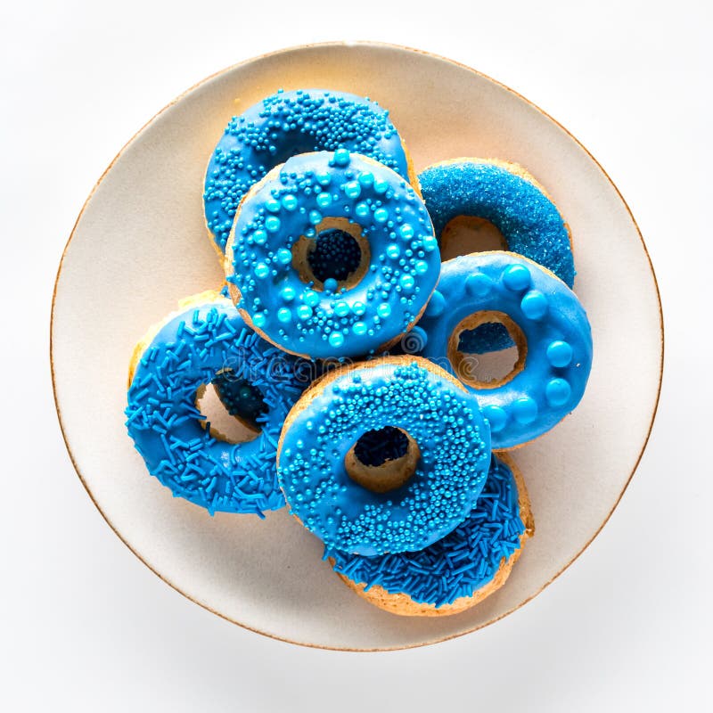 A Plate Topped with a Pile of Decorated Blue Donuts. Stock Photo ...