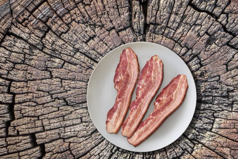 Plateful of Three Pork Belly Bacon Rashers on Old Cracked Stump Surface ...